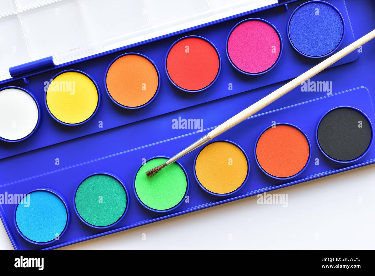 Colorful watercolor paints and fine paint brush in blue box on white ...