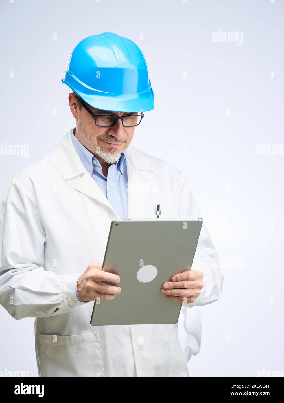 Middle age engineer in lab coat and hard hat. Scientist, architect with ...
