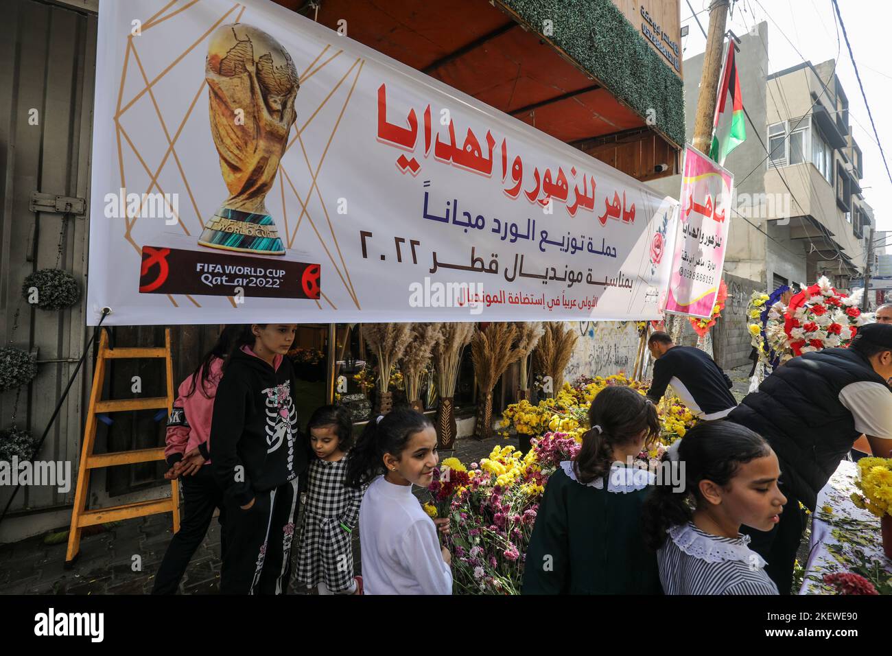 Palestinians in a flower shop distribute flowers to passers-by, to ...