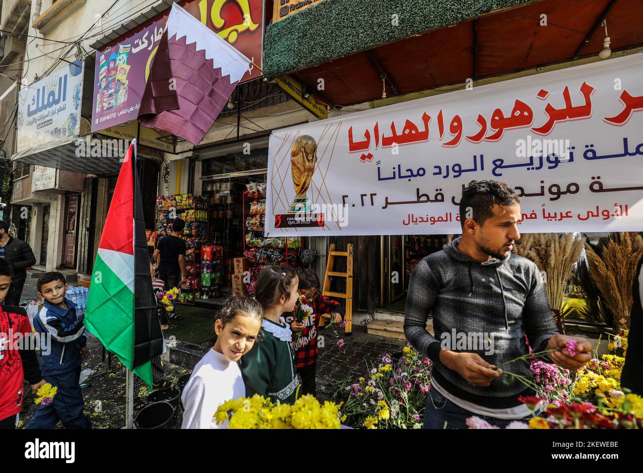 Palestinians in a flower shop distribute flowers to passers-by, to ...