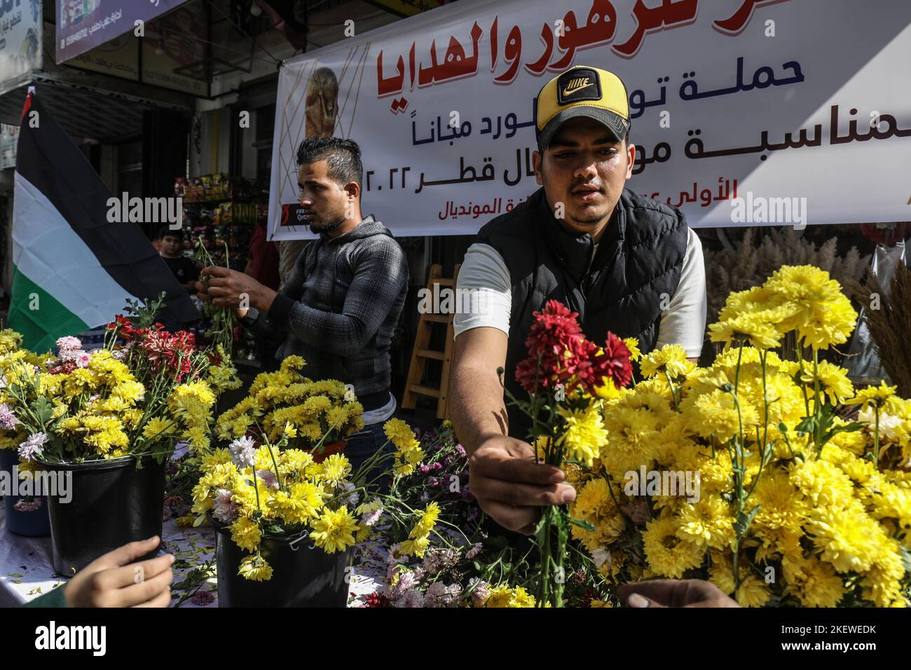 Palestinians in a flower shop distribute flowers to passers-by, to ...