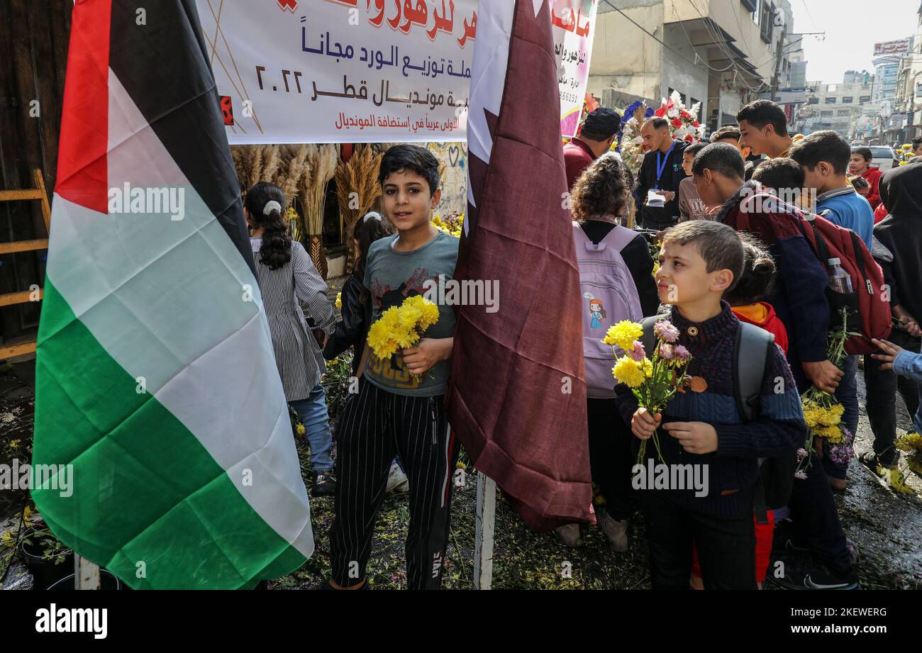 Palestinians in a flower shop distribute flowers to passers-by, to ...