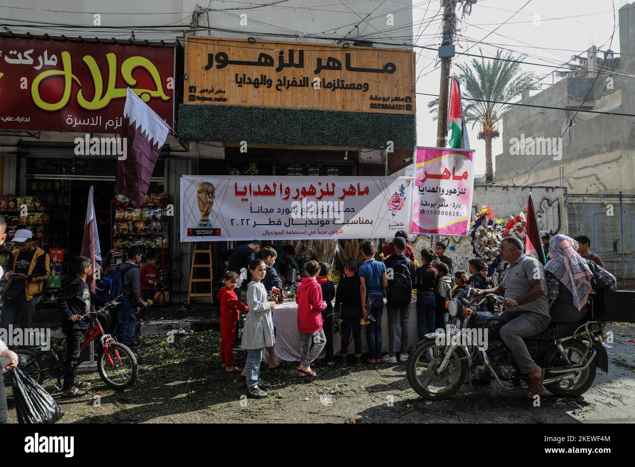 Palestinians in a flower shop distribute flowers to passers-by, to ...
