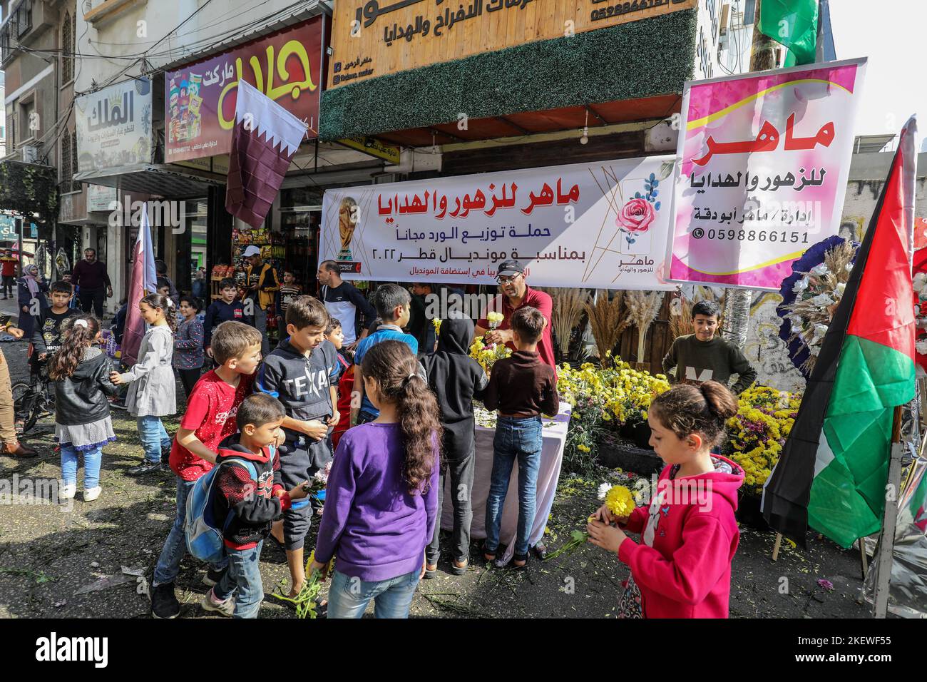 Palestinians in a flower shop distribute flowers to passers-by, to ...