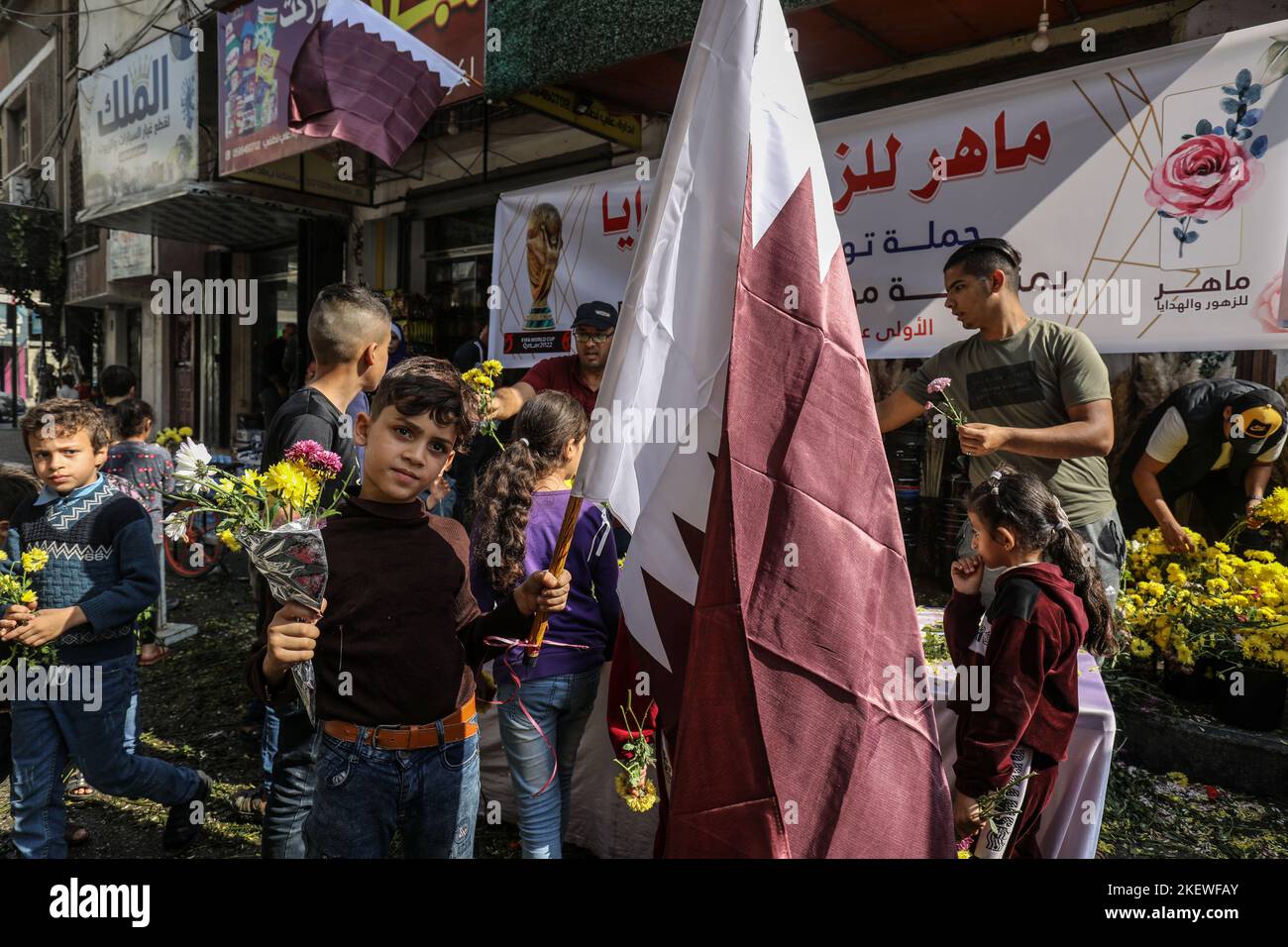 Palestinians in a flower shop distribute flowers to passers-by, to ...