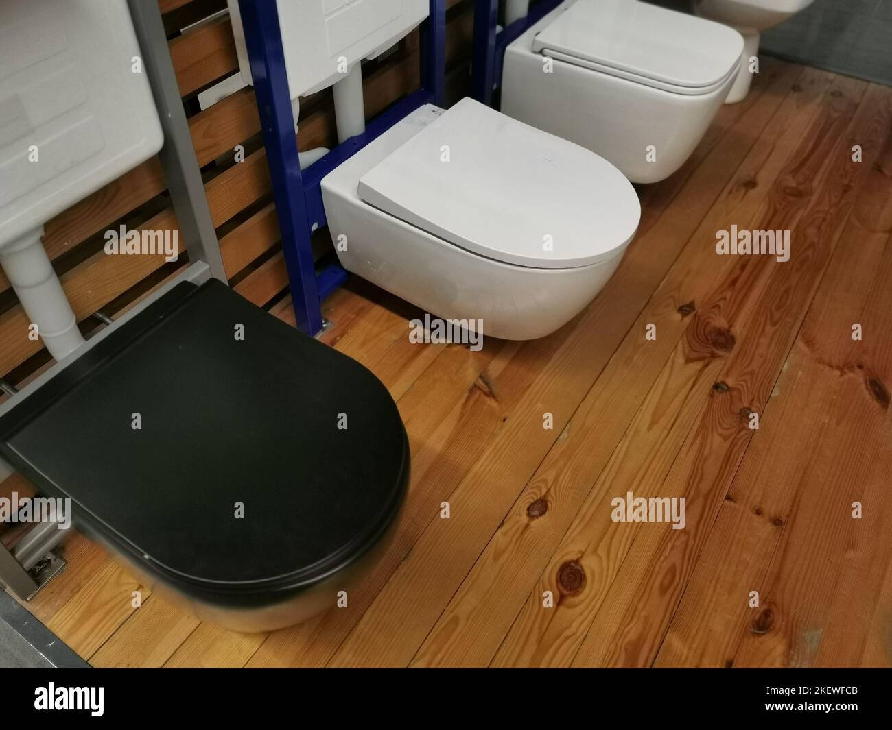 Exhibition of samples of white toilet bowls standing in a row in the ...