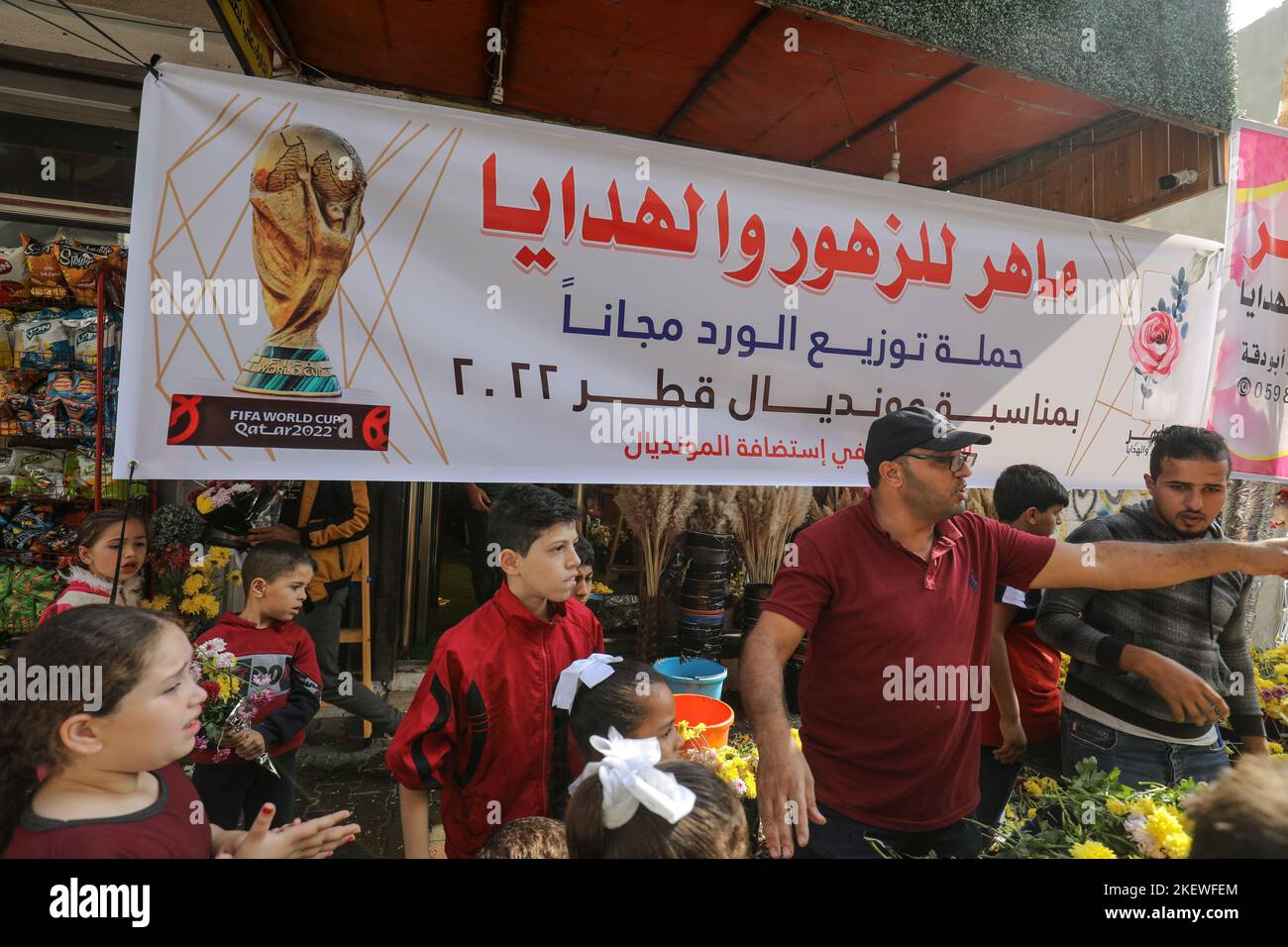 Palestinians in a flower shop distribute flowers to passers-by, to ...