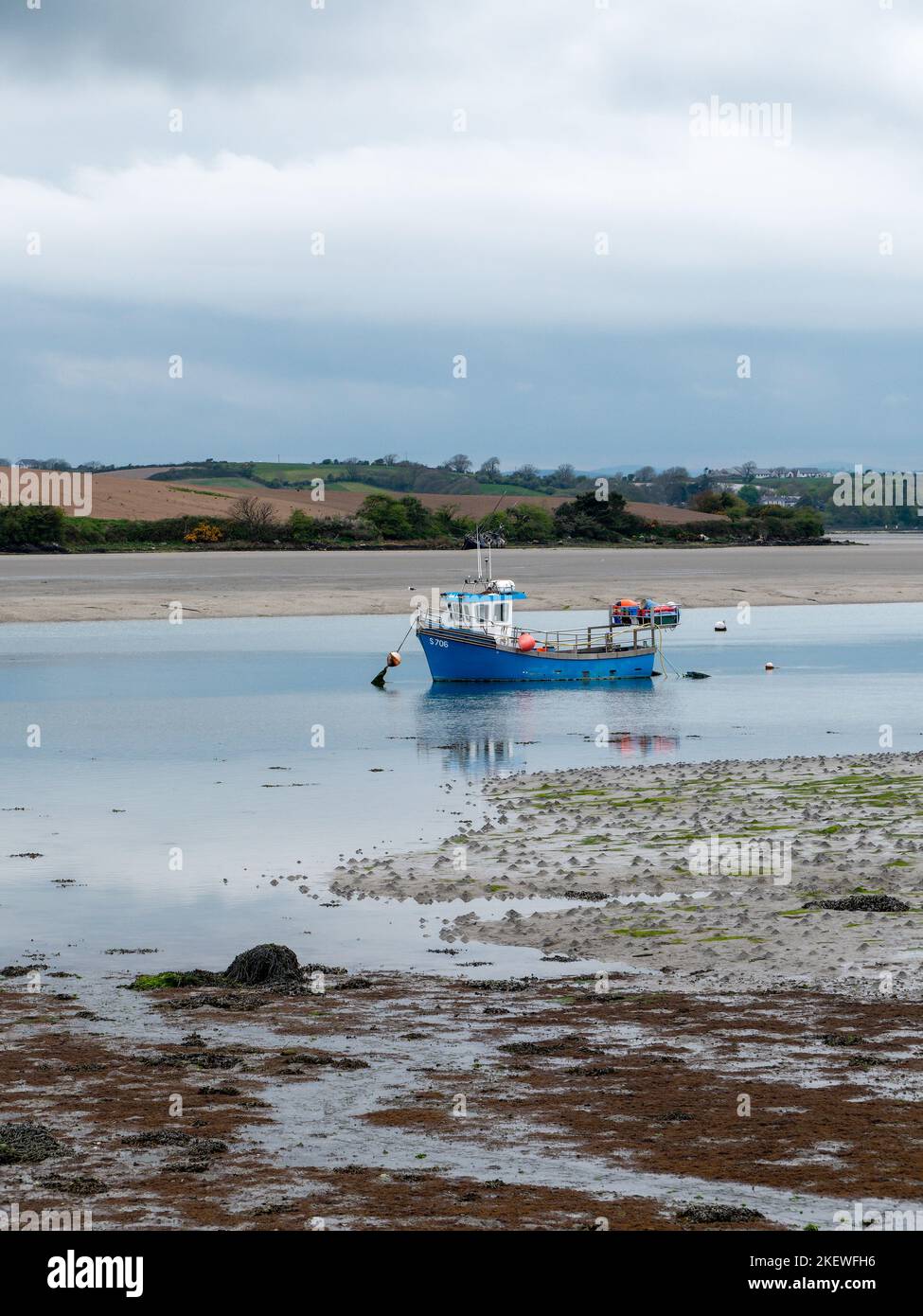 Clonakilty Bay. A small blue fishing boat is anchored. Open seabed ...