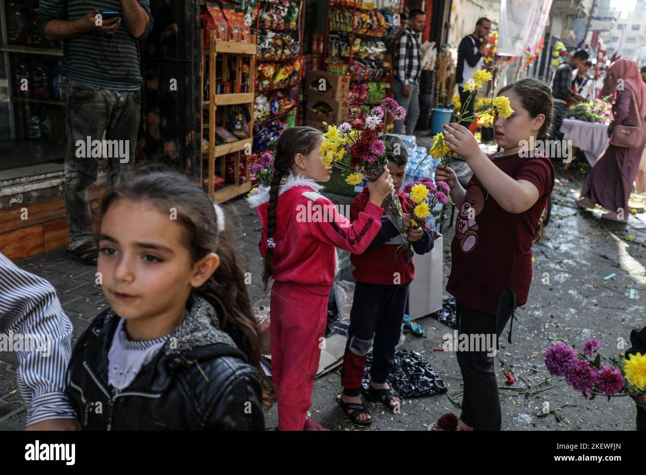 Palestinians in a flower shop distribute flowers to passers-by, to ...