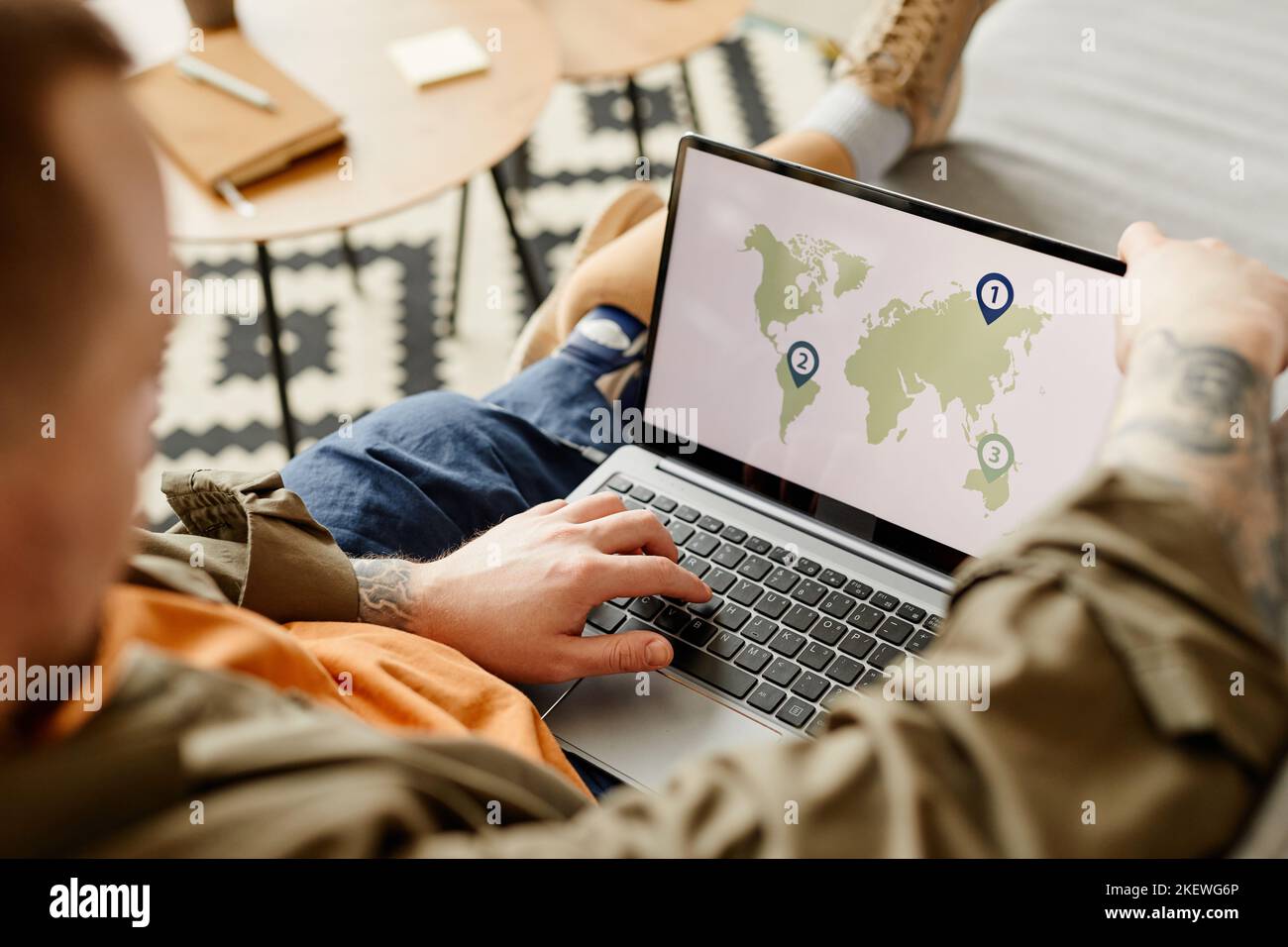 Close up of man with prosthetic leg using laptop, world map on screen ...