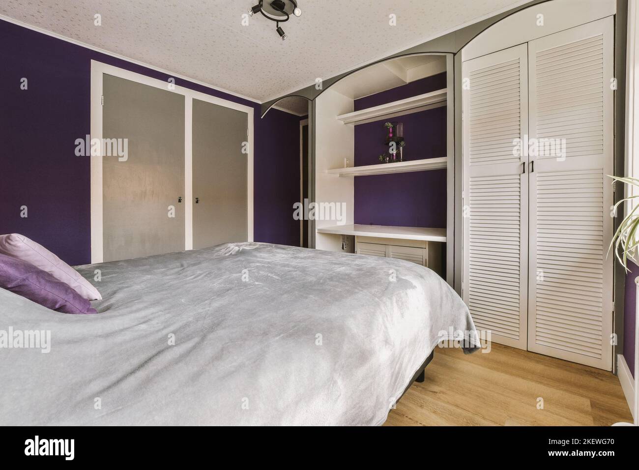 Home interior design of bedroom with bed and wooden wardrobe placed in ...