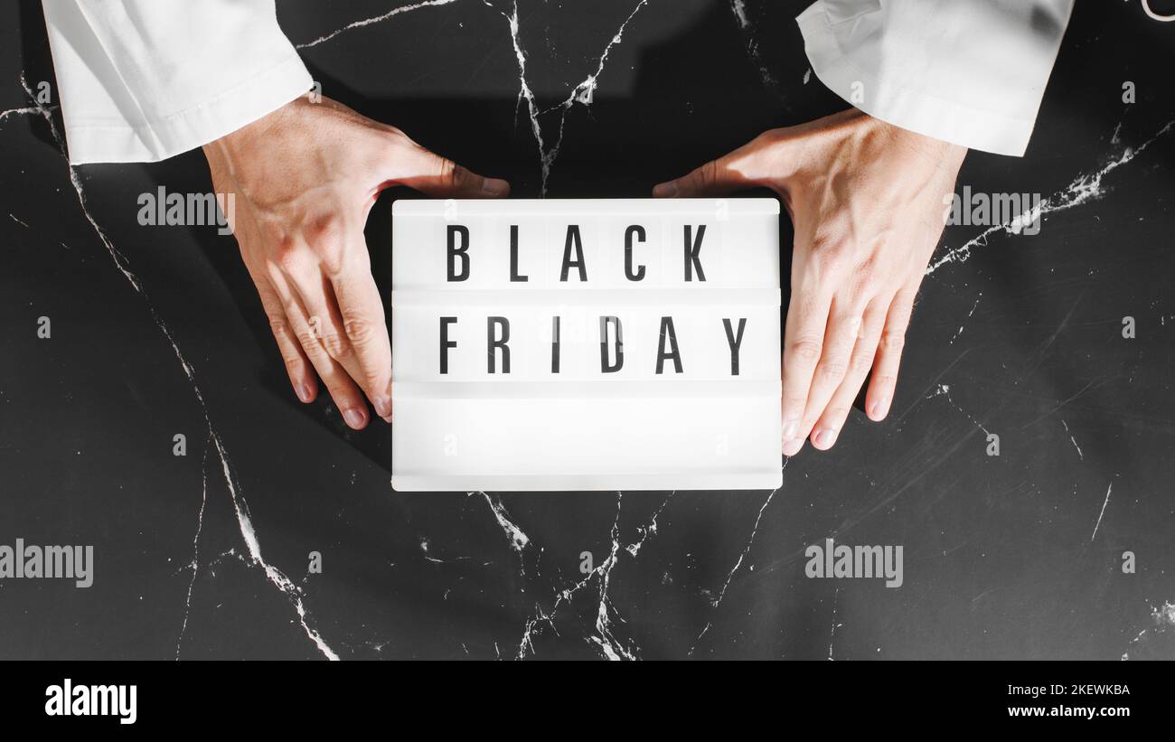 Hands Placing Black Friday Sign Stock Photo - Alamy