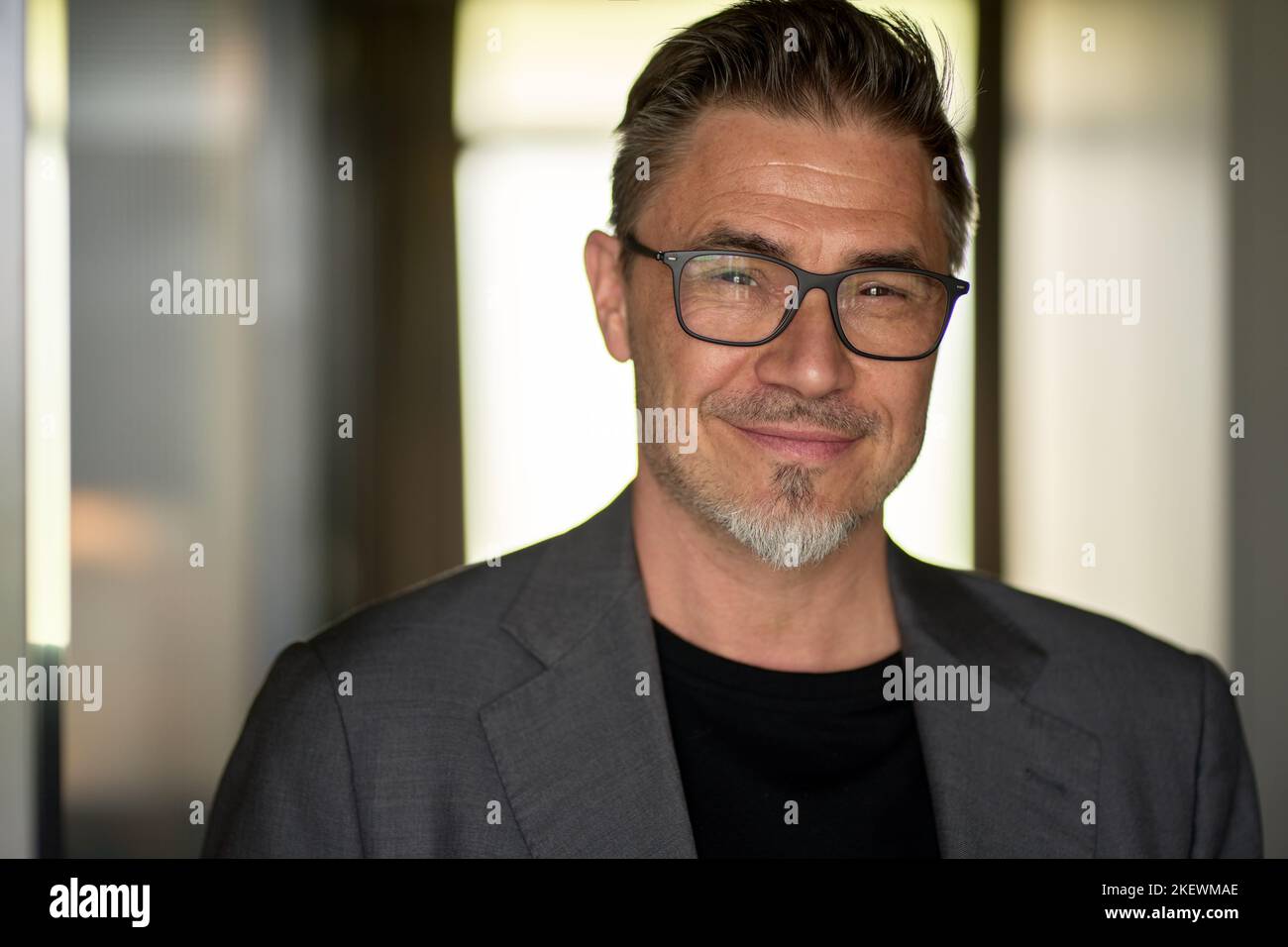 Business portrait - happy smiling businessman at office wearing glasses ...