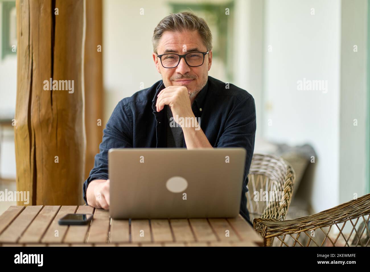 Middle aged man working with laptop computer at home outdoor i on ...