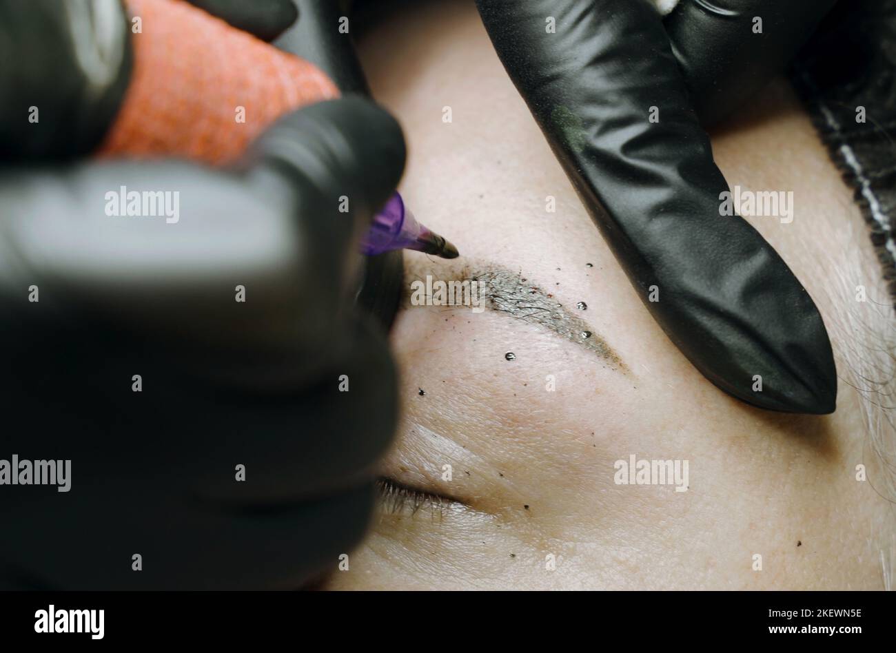 A special needle tattoo machine makes a permanent make-up correction of ...