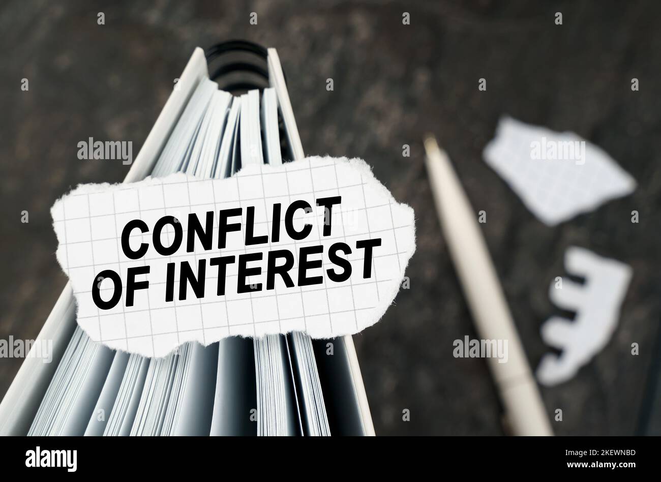 On the table is a notebook on which lies a piece of torn paper with the ...