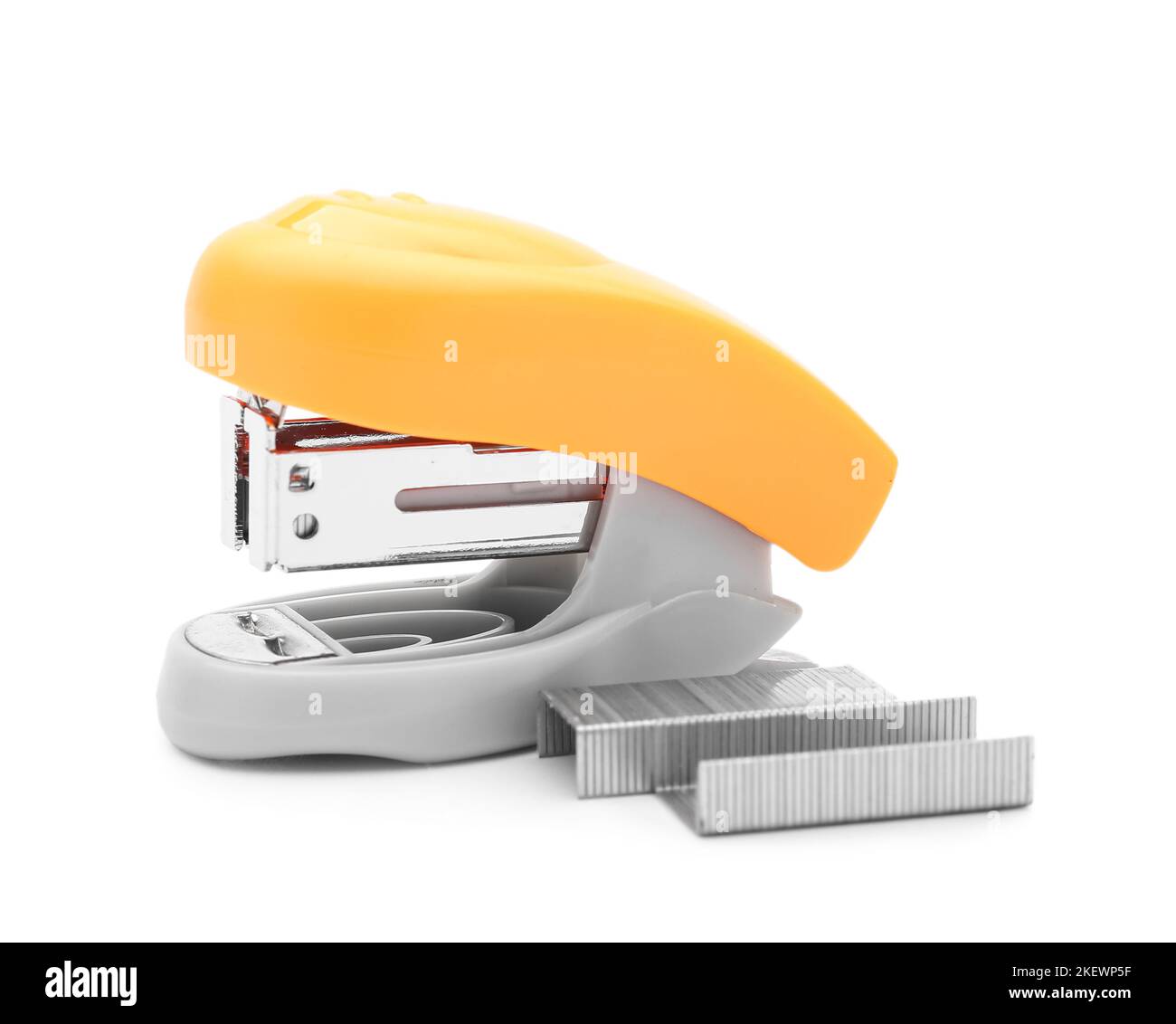Orange stapler and staples on white background Stock Photo - Alamy