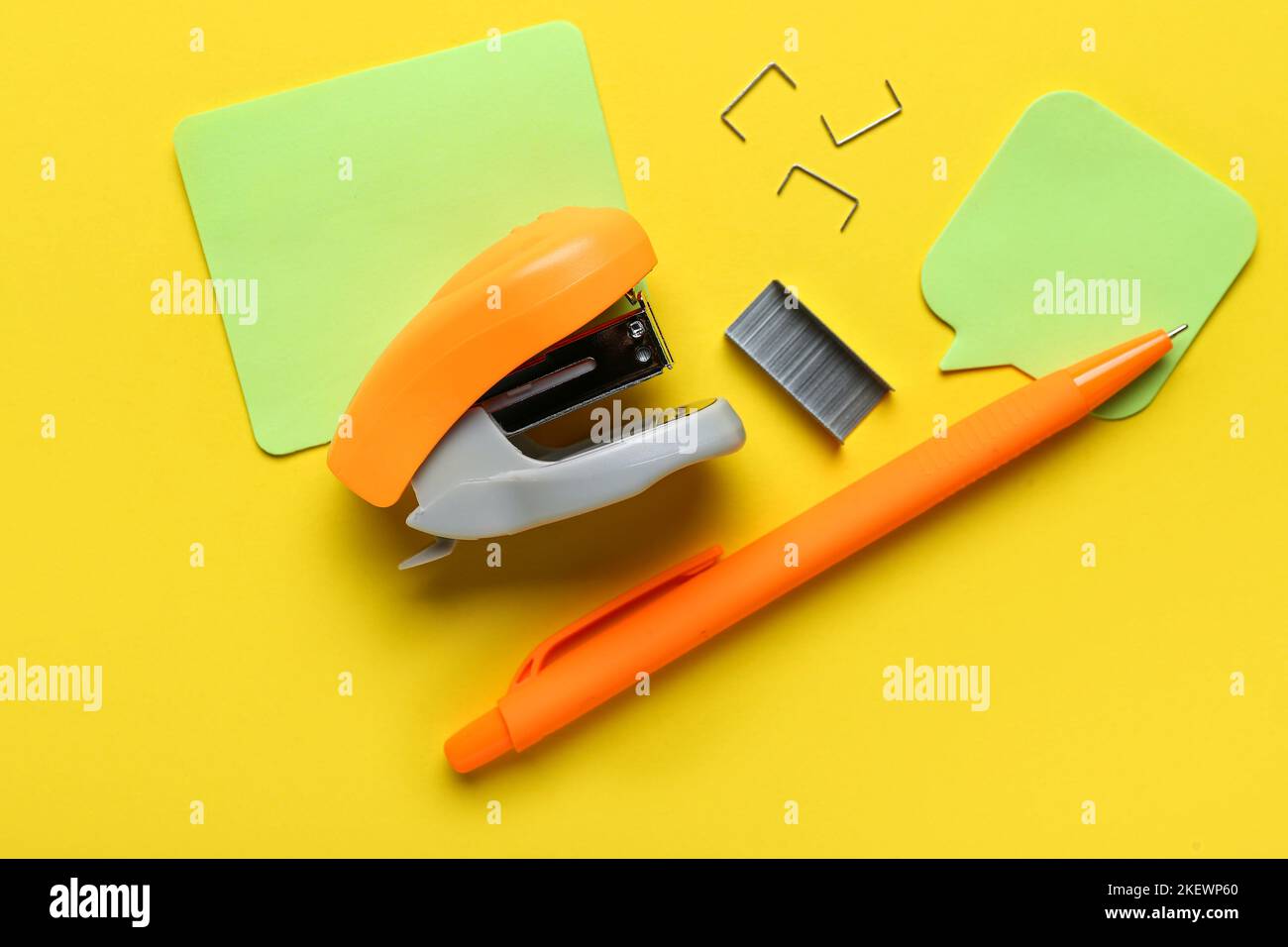 Stapler, staples, pen and sticky notes on yellow background Stock Photo ...