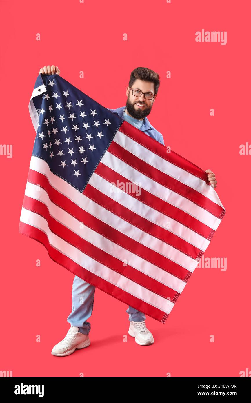 Handsome bearded man with USA flag on red background Stock Photo - Alamy