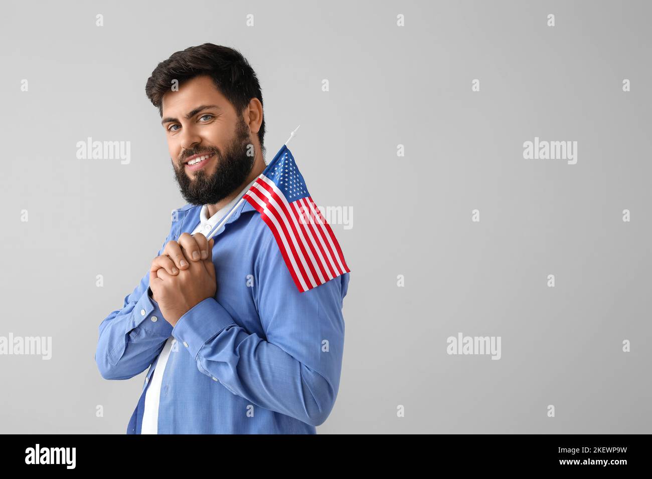 Handsome bearded man with USA flag on grey background Stock Photo - Alamy
