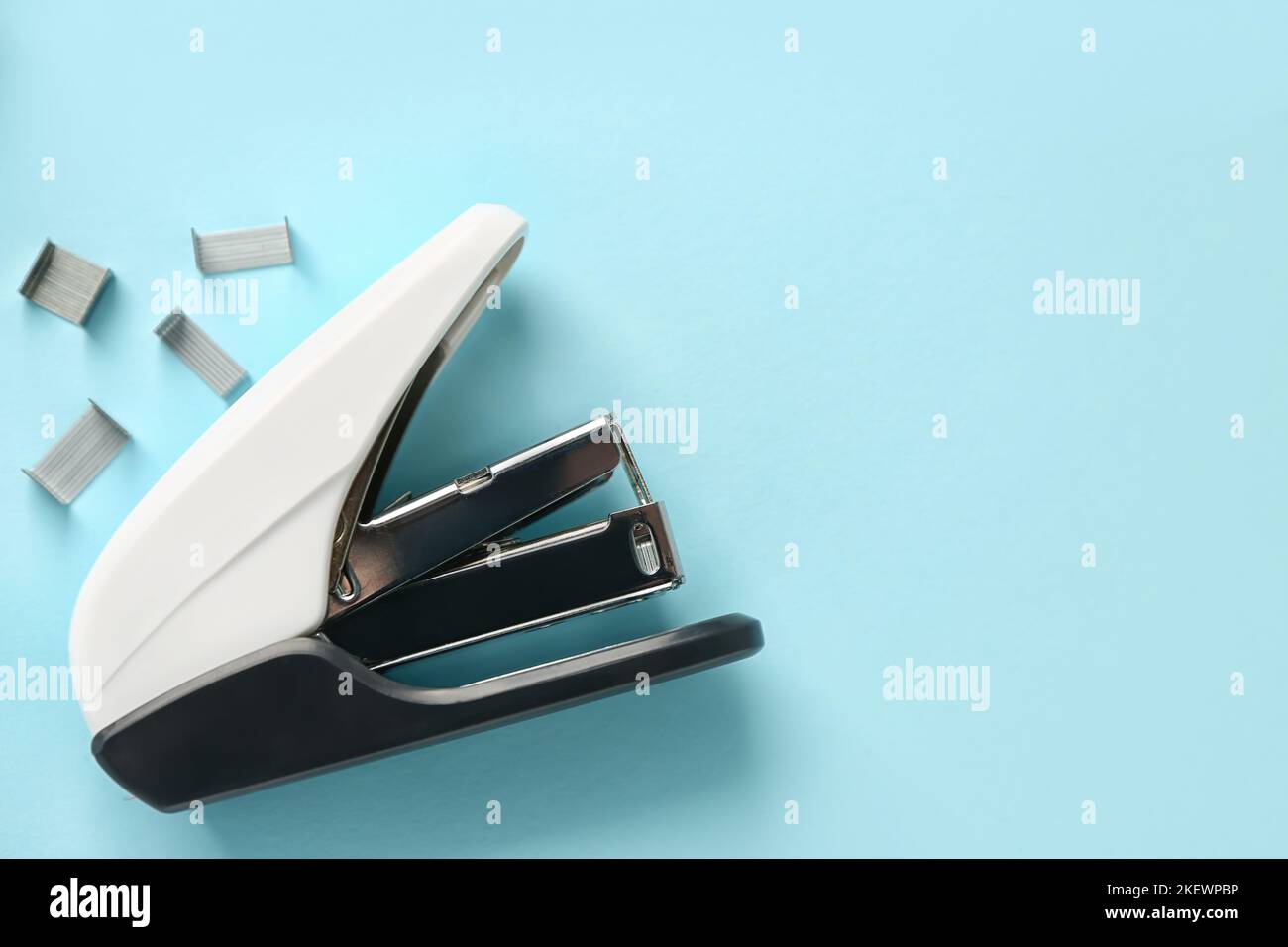 Office stapler with staples on color background Stock Photo - Alamy