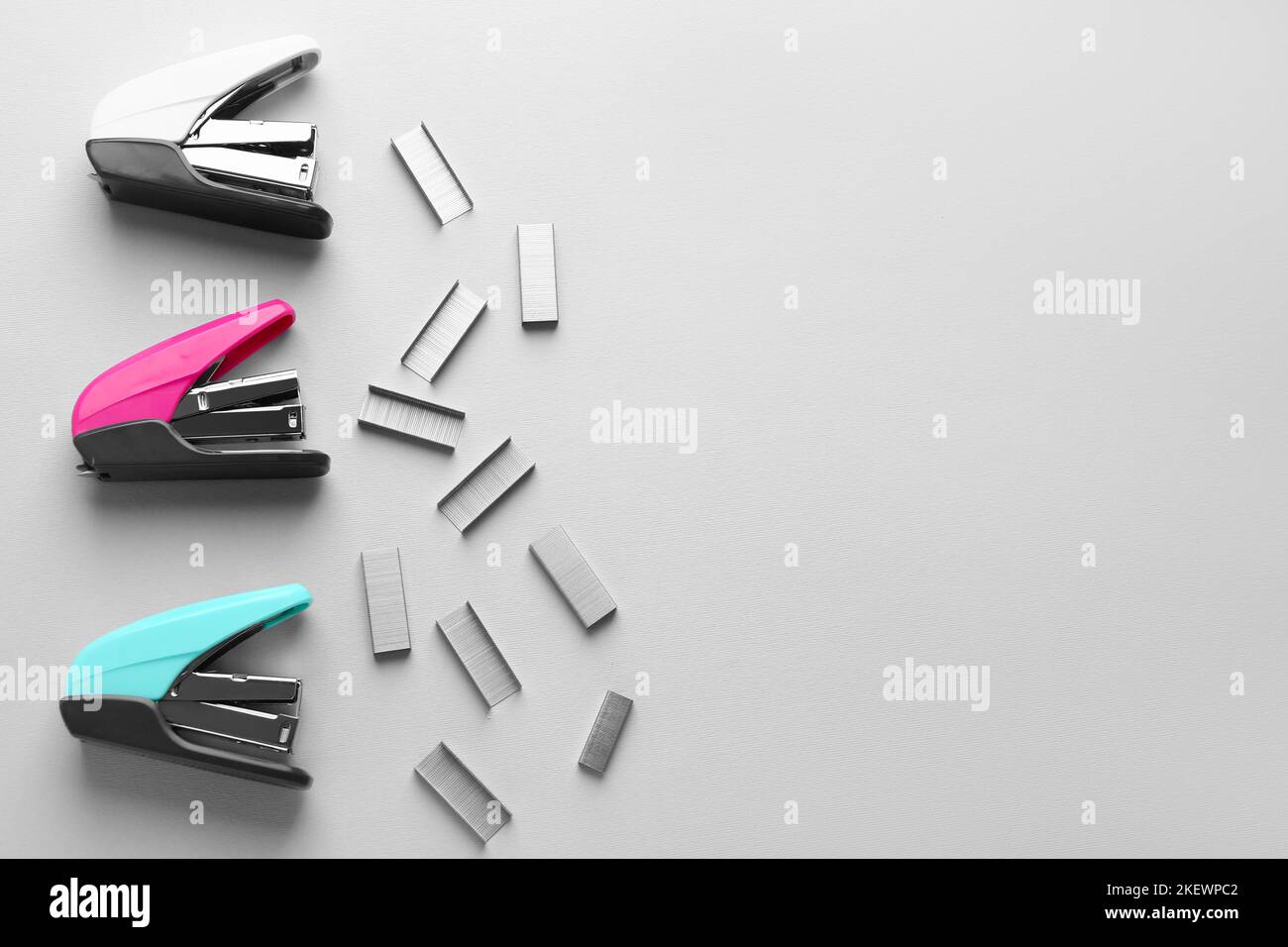 Office staplers and staples on light background Stock Photo - Alamy