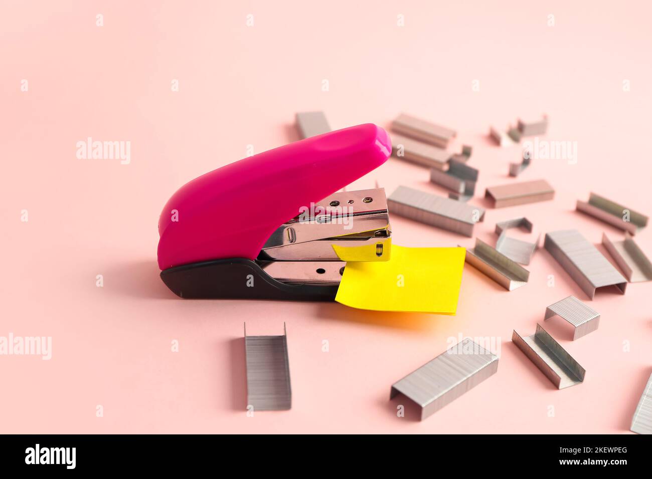 Office stapler with sticky notes and staples on color background Stock ...