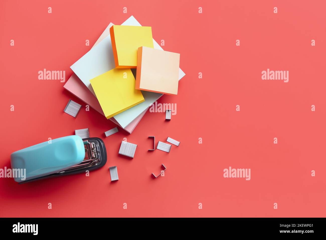 Stapler, staples and sticky notes on red background Stock Photo - Alamy