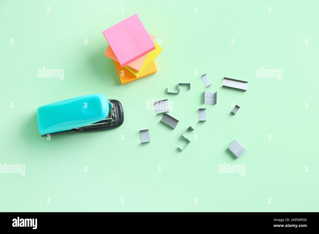 Stapler, staples and sticky notes on color background Stock Photo - Alamy