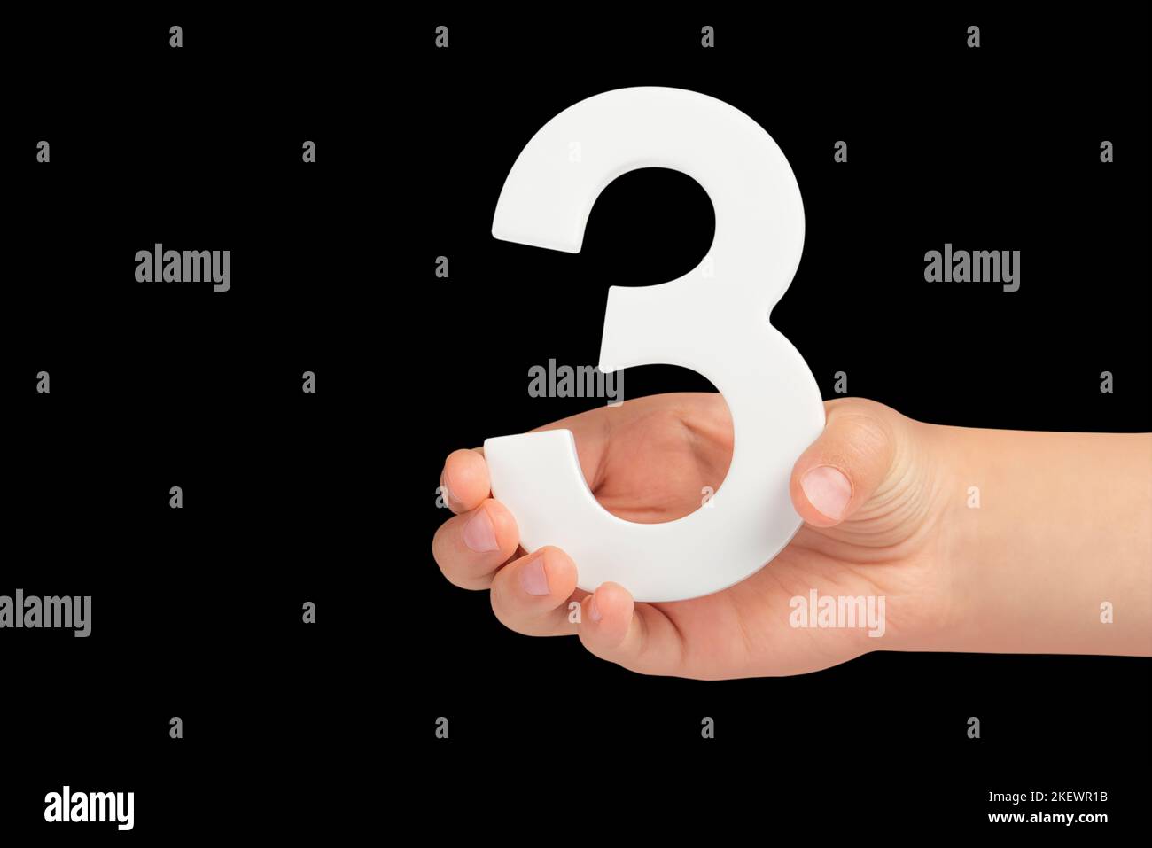 number three in hand isolated on black background. Number three in a ...