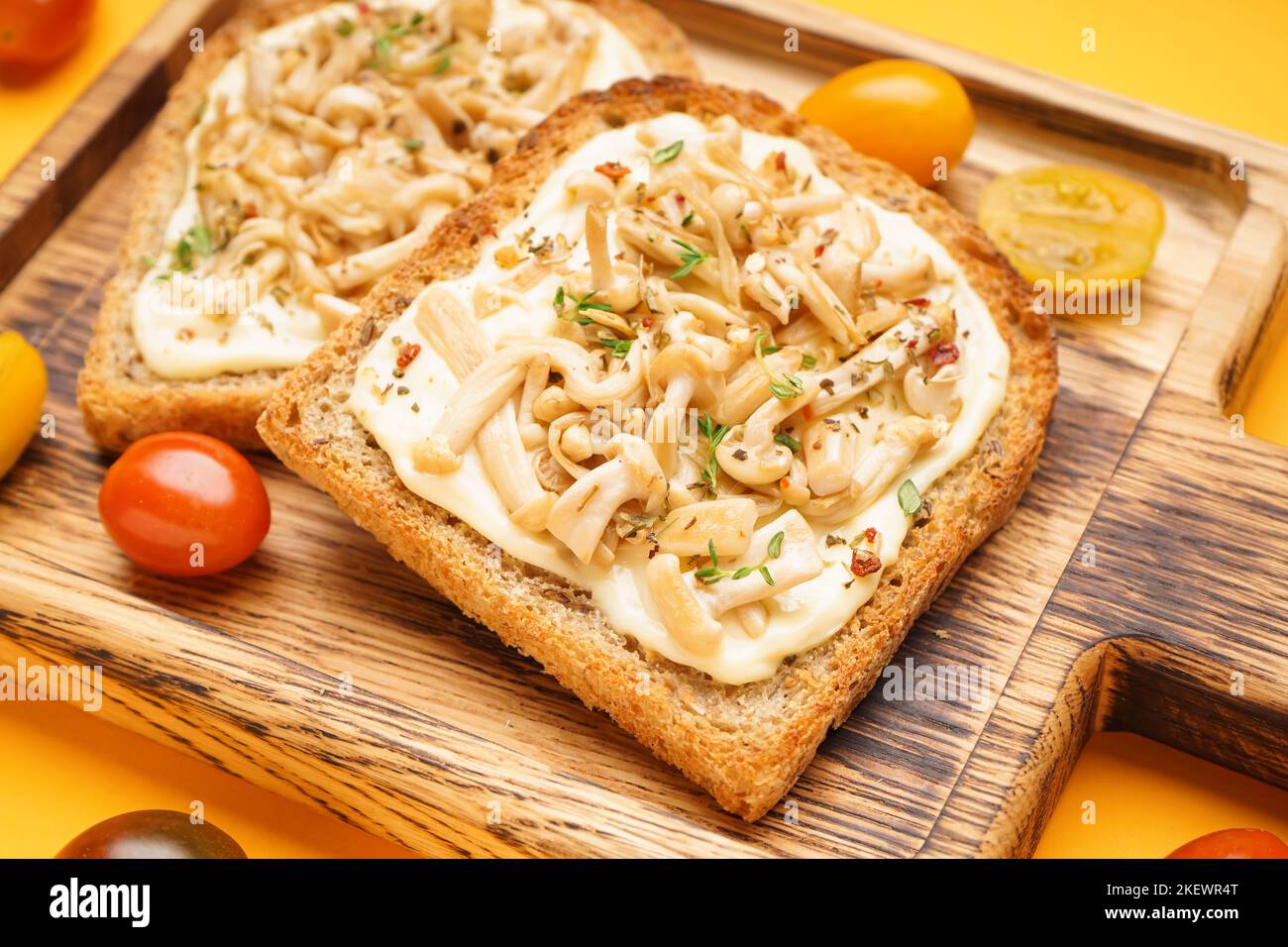 Wooden board of tasty toasts with cream cheese, mushrooms and tomatoes ...