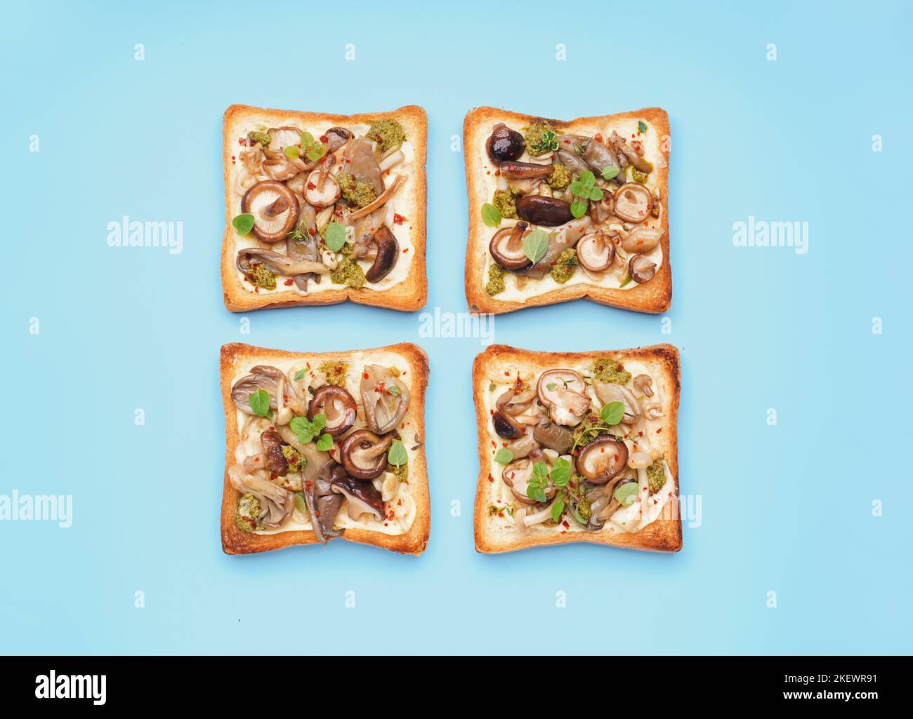 Delicious toasts with cream cheese, mushrooms and pesto sauce on color ...