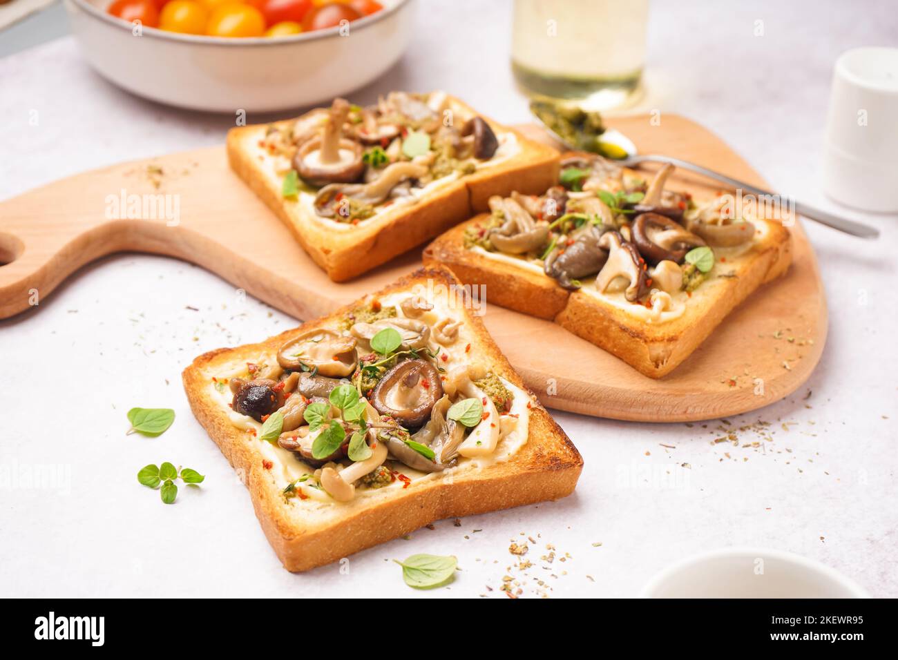 Wooden board of tasty toasts with cream cheese, mushrooms and pesto ...