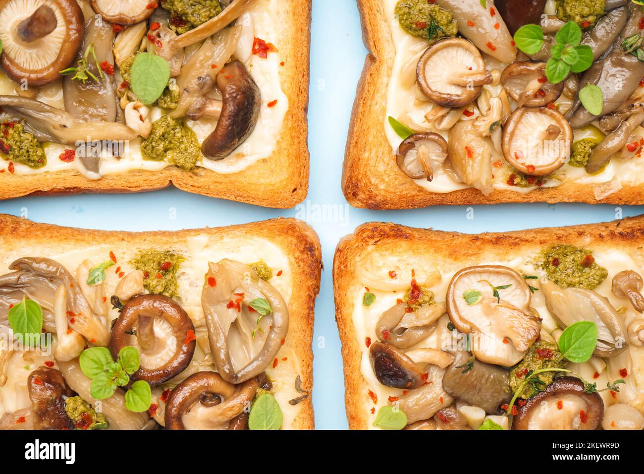 Delicious toasts with cream cheese, mushrooms and pesto sauce on color ...