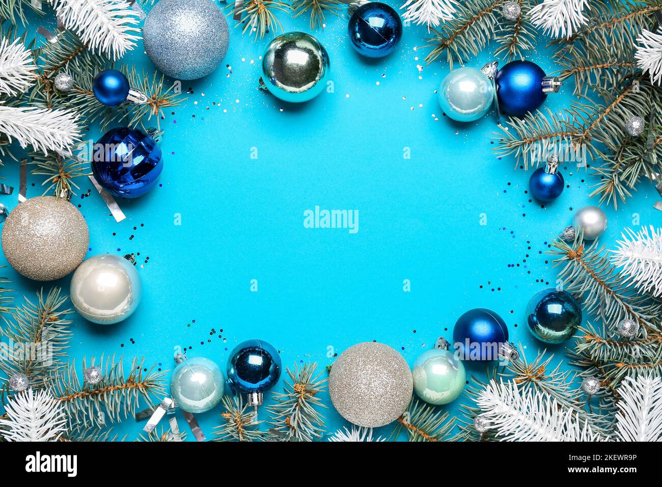 Frame made of beautiful Christmas balls and fir branches on color ...