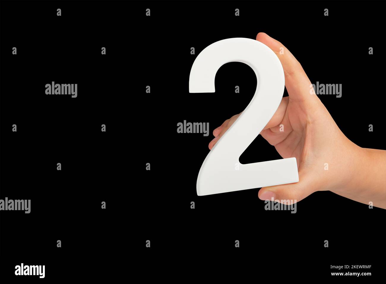 number two in hand isolated on black background. Number two white in a ...