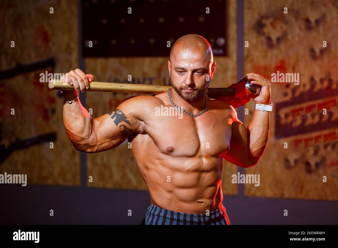 Strong athletic man posing with a sports hammer on the background of ...