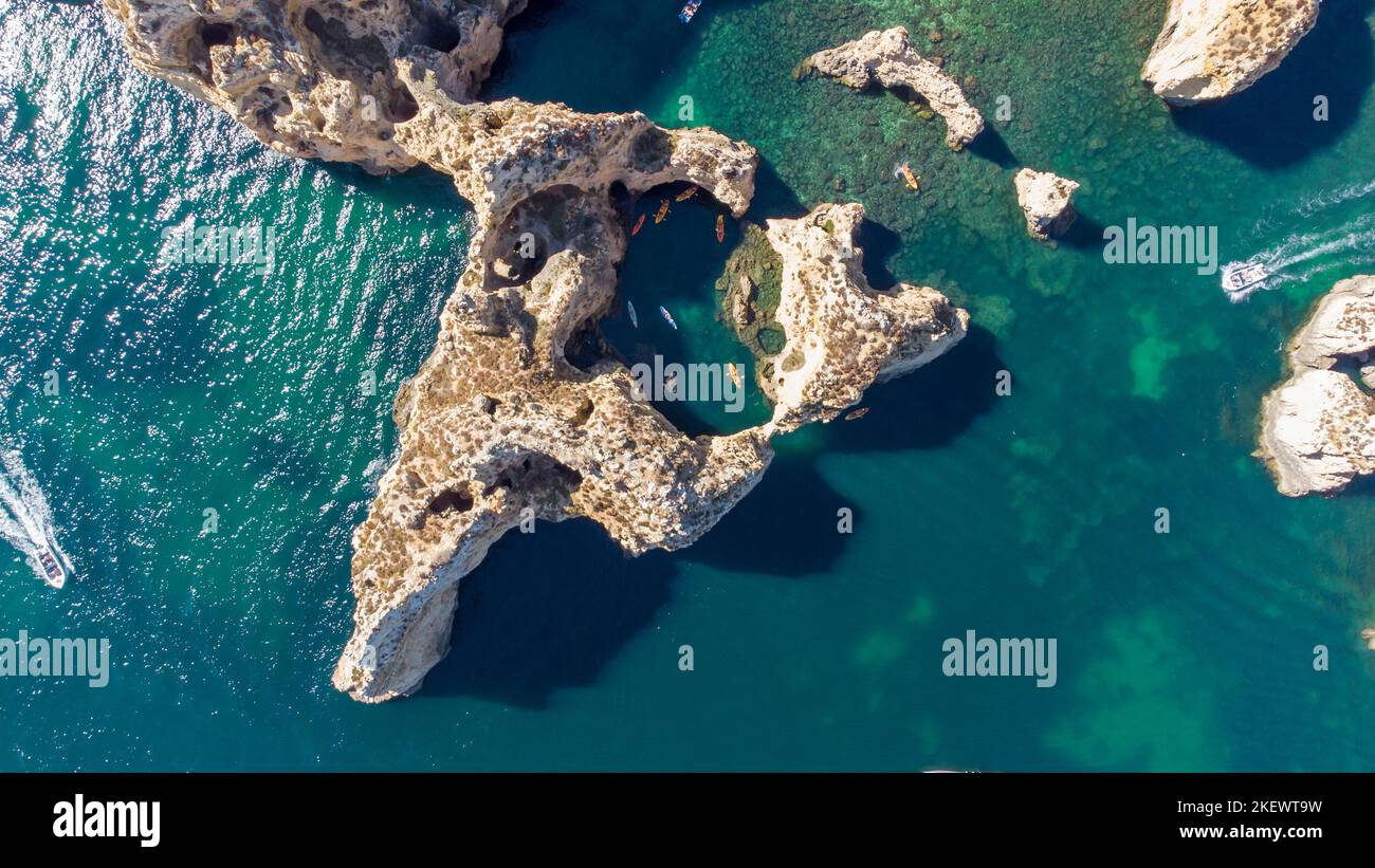 Aerial drone shot of kayaks and boats passing around magical Ponta da ...