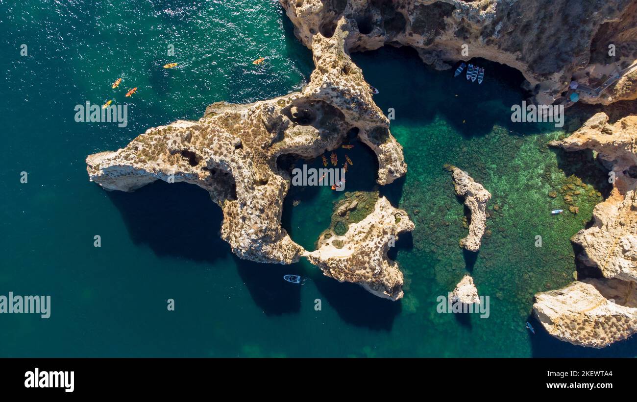 Aerial drone shot of kayaks and boats passing around magical Ponta da ...