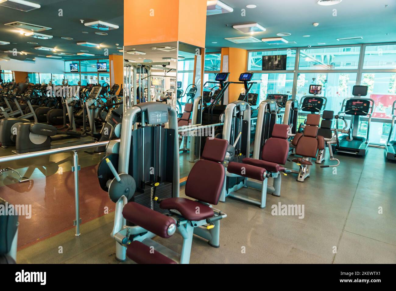Interior of modern gym fitness room with large windows and treadmills ...