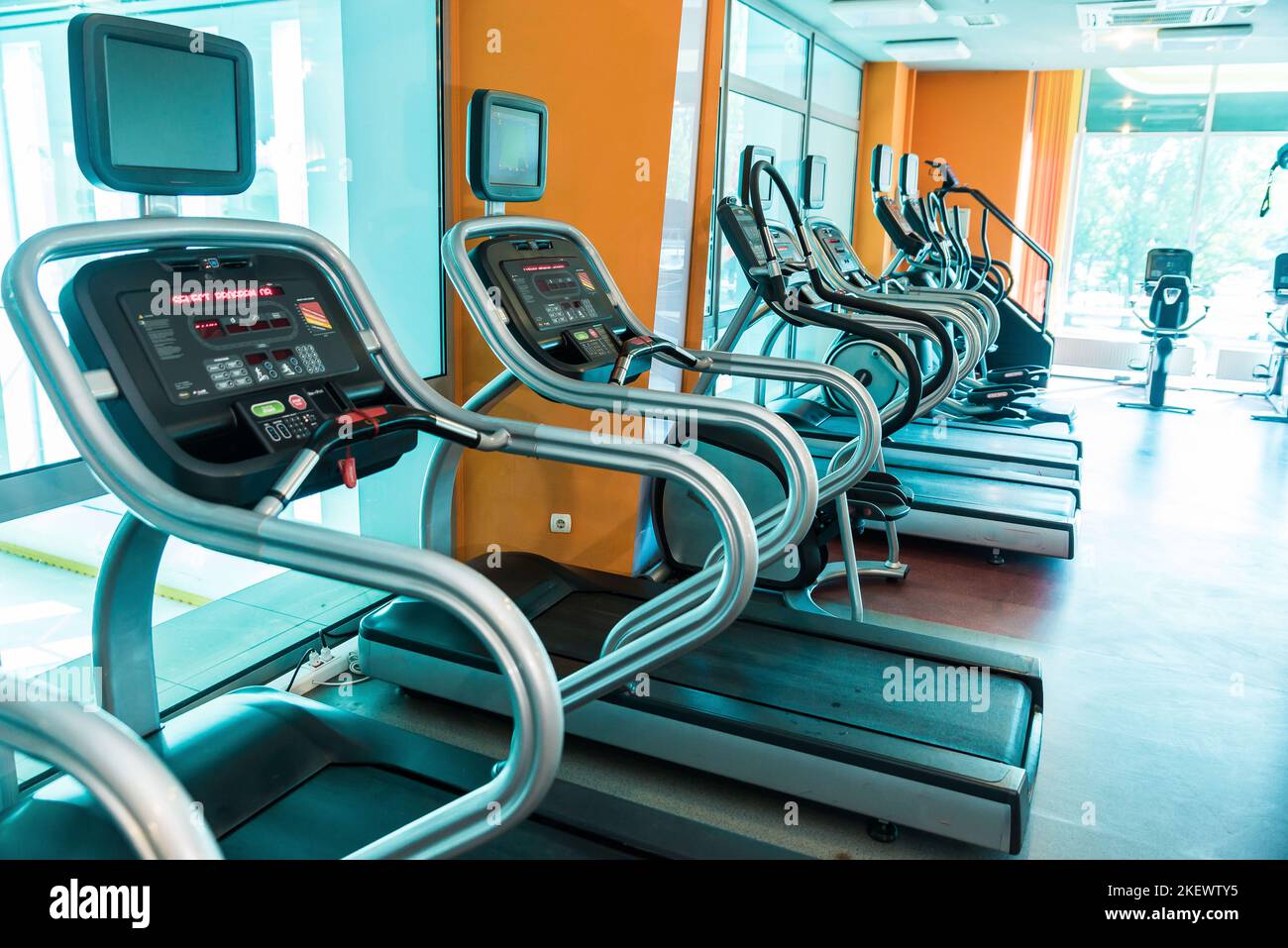 Interior of modern gym fitness room with large windows and treadmills ...