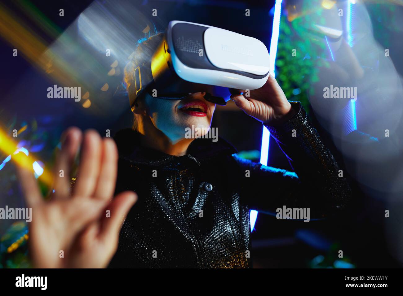 trendy woman in metaverse in vr goggles exploring Stock Photo - Alamy