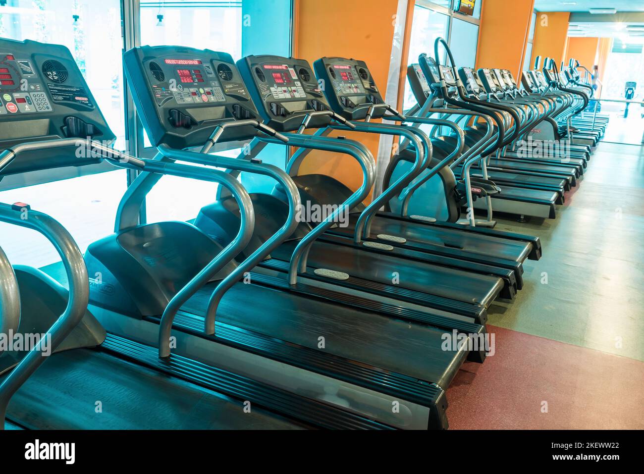 Interior of modern gym fitness room with large windows and treadmills ...