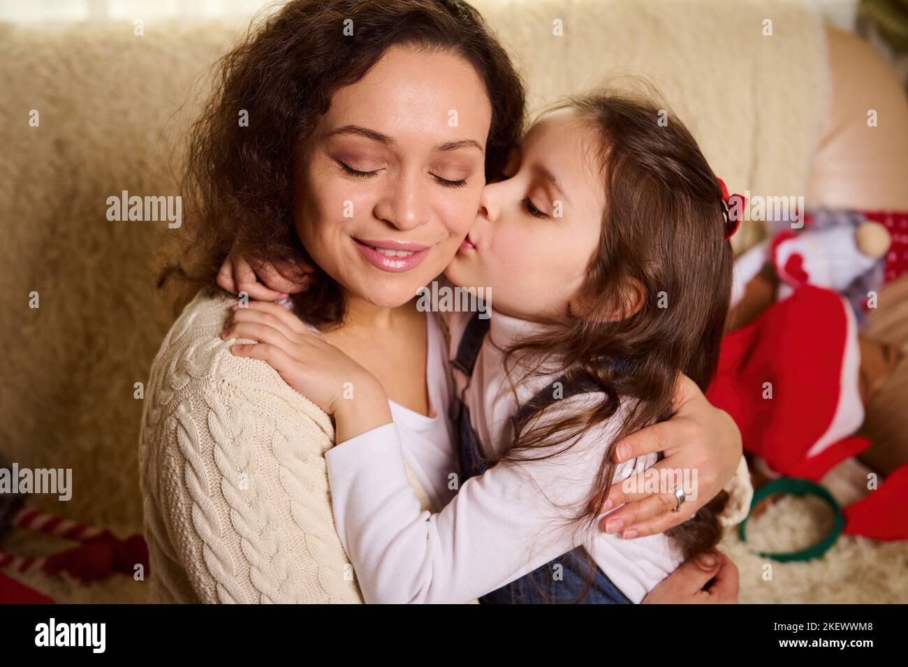 Adorable little child, cute baby girl, lovely daughter hugging and kissing her loving mother, in ...