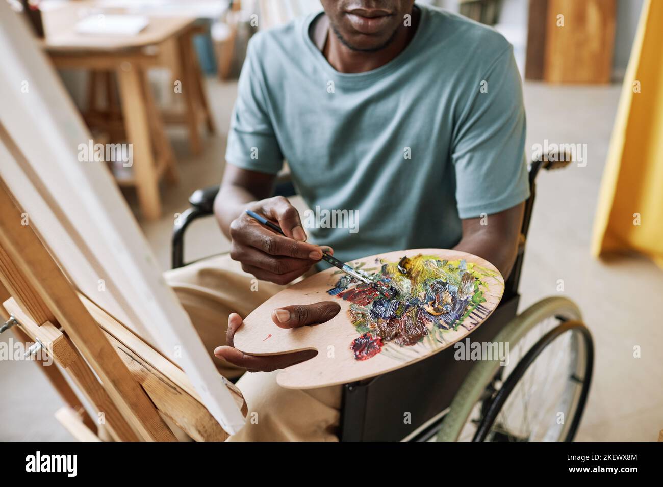 Close-up of palette with mixed acrylic paints held by young creative ...