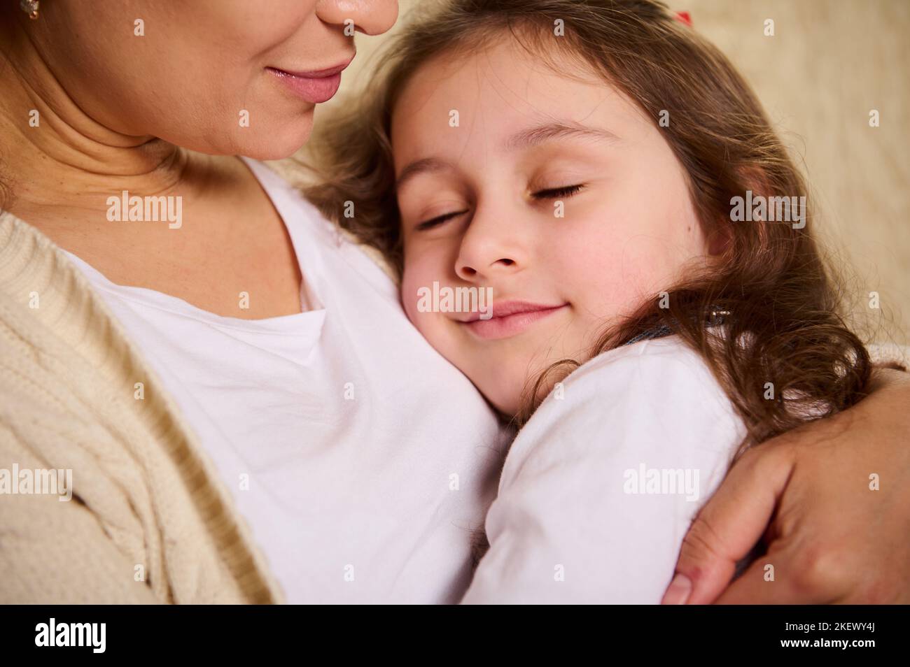 Adorable Caucasian little girl daughter falling asleep on her mother's ...