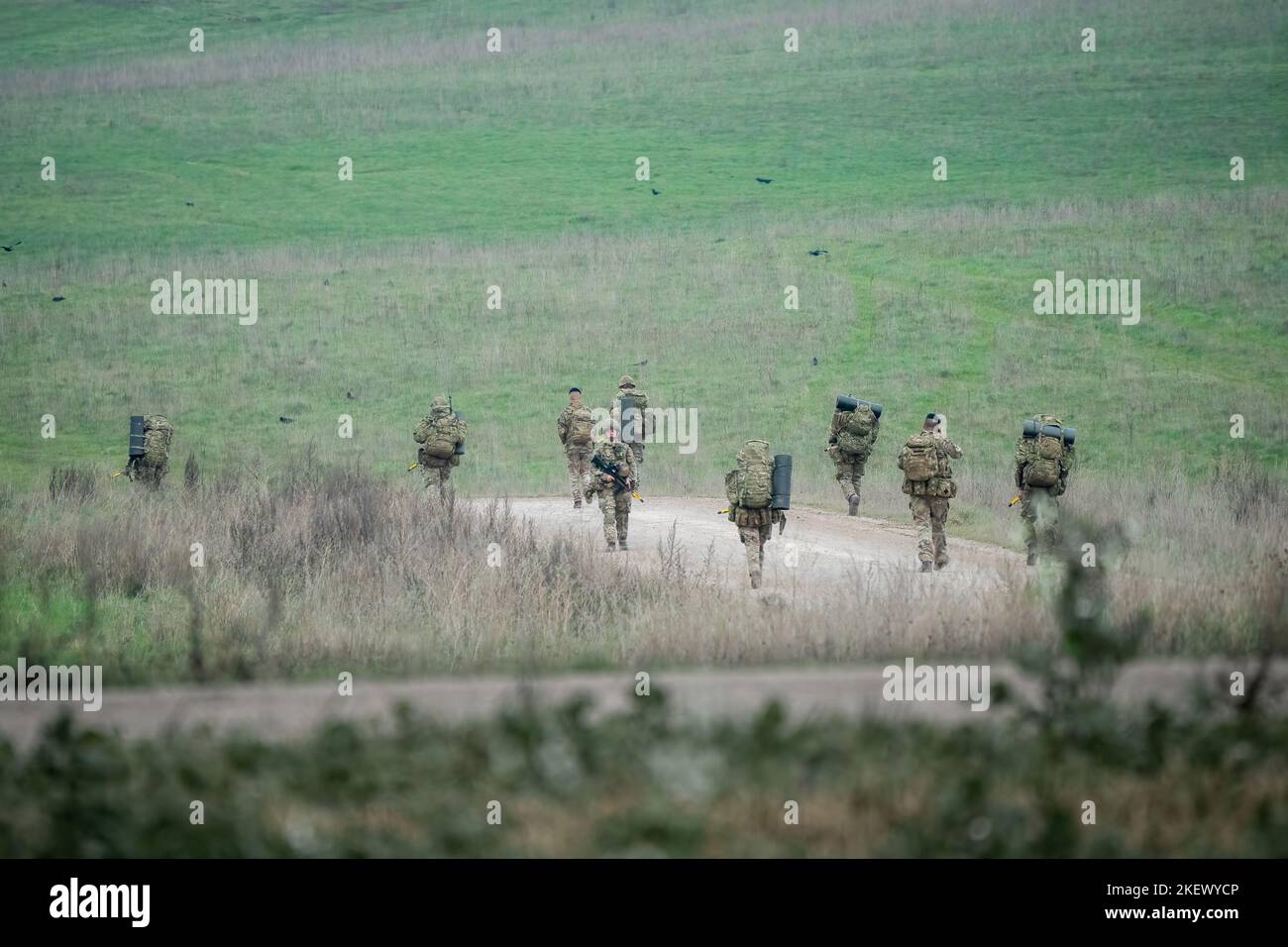 a unit of British army soldiers on a loaded march, military exercise ...