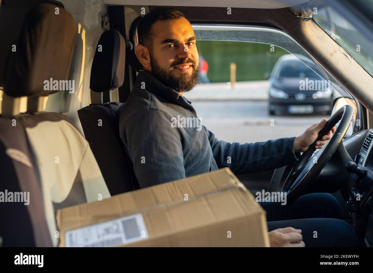 Delivery man working inside a van next to a parcel ready to drive ...