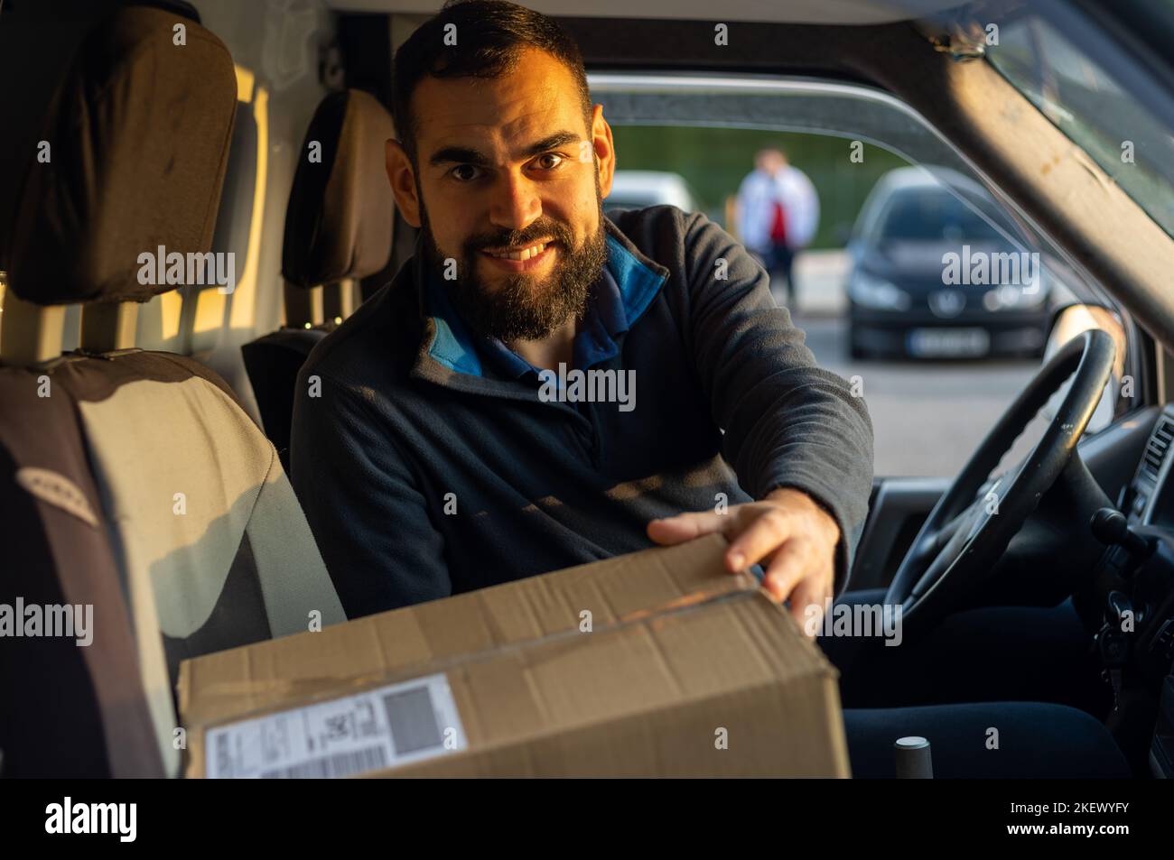 Delivery man working inside a van next to a parcel ready to drive ...