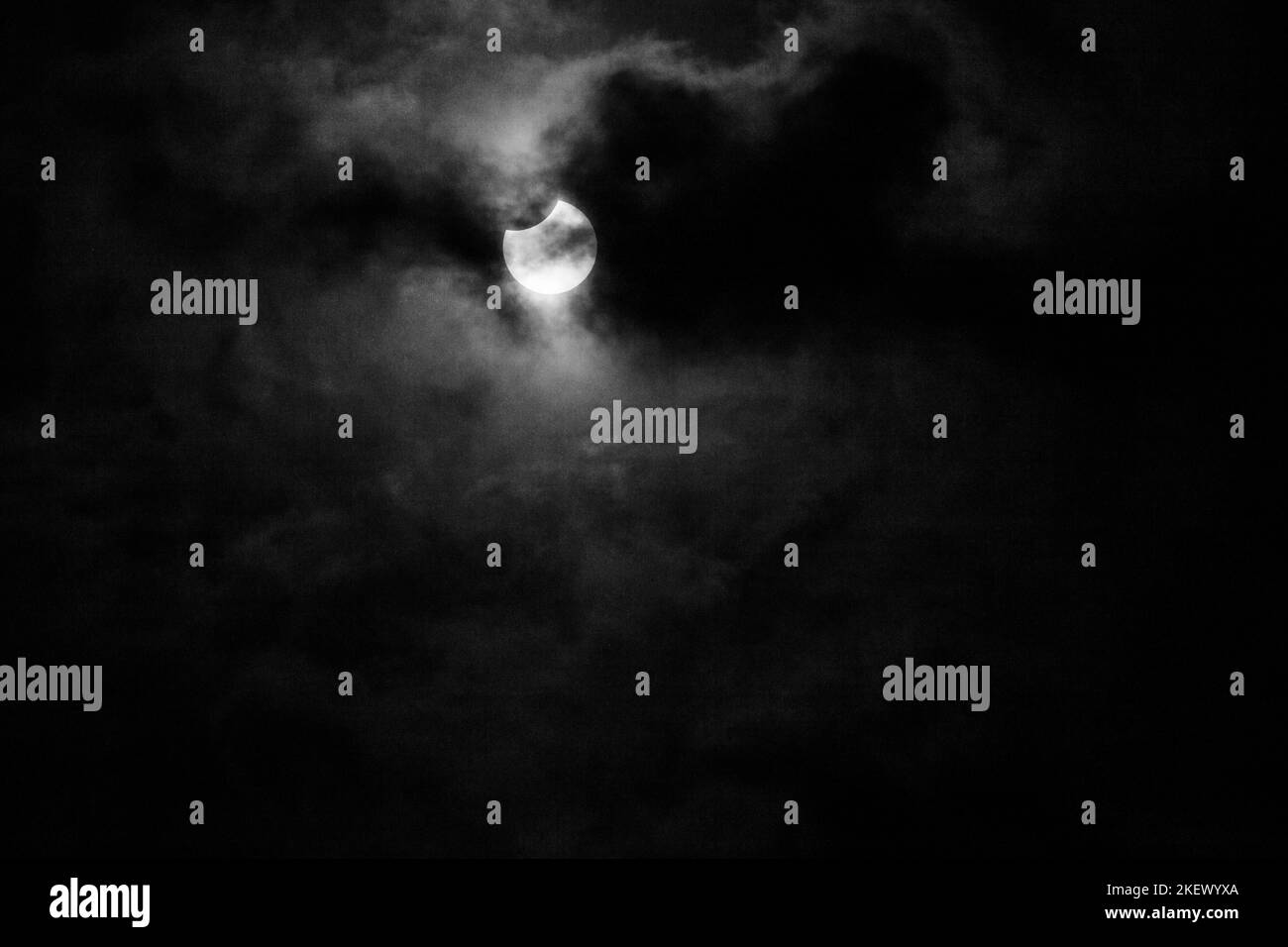 Partial solar eclipse with cloudy sky Stock Photo - Alamy